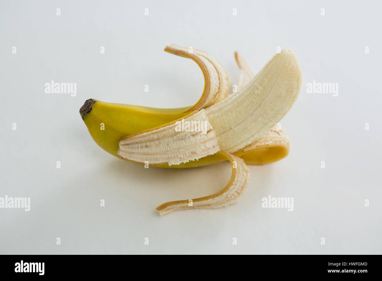 Close-up of pealed banana on white background Stock Photo - Alamy