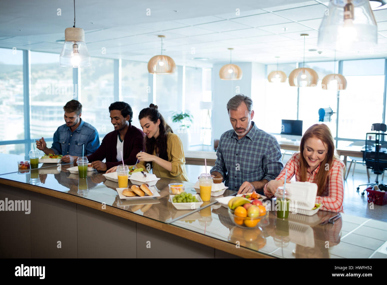 Creative business team having meal at office Stock Photo - Alamy