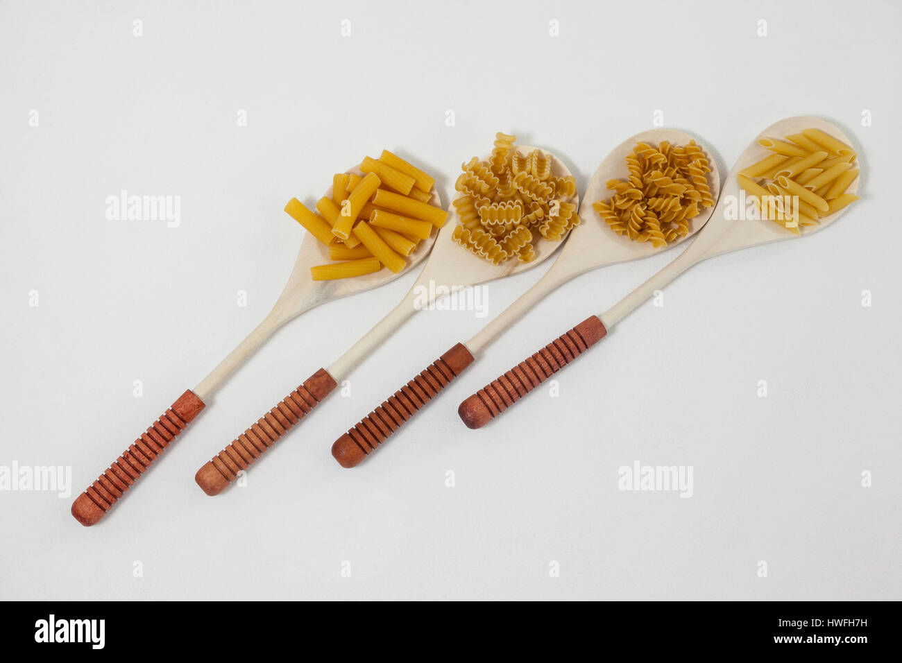 Spoons filled with varieties of pasta on white background Stock Photo ...