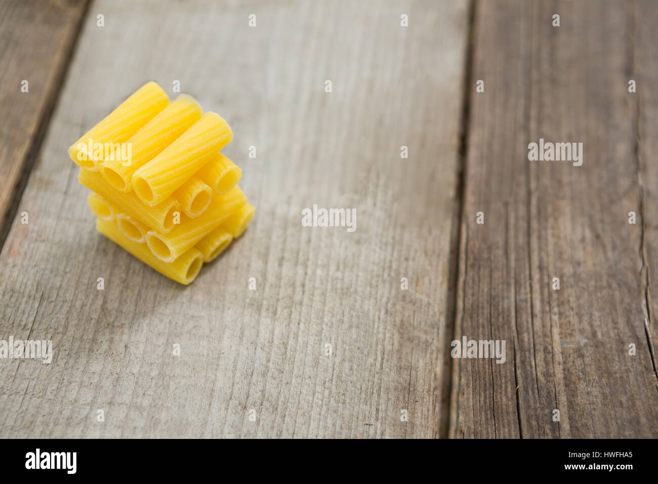 Stack of macaroni pasta on wooden surface Stock Photo - Alamy