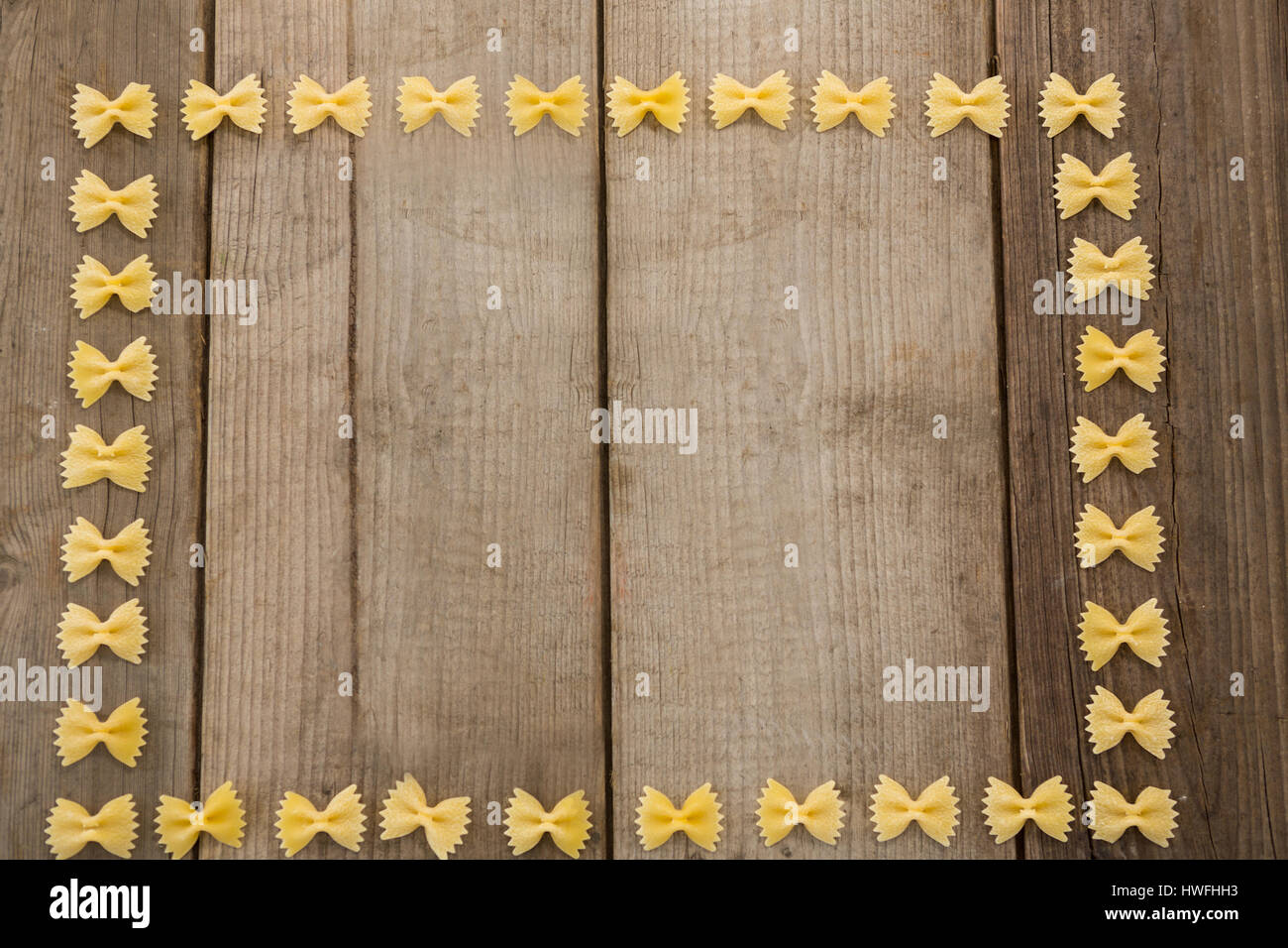 Farfalle pasta forming frame on wooden surface Stock Photo - Alamy