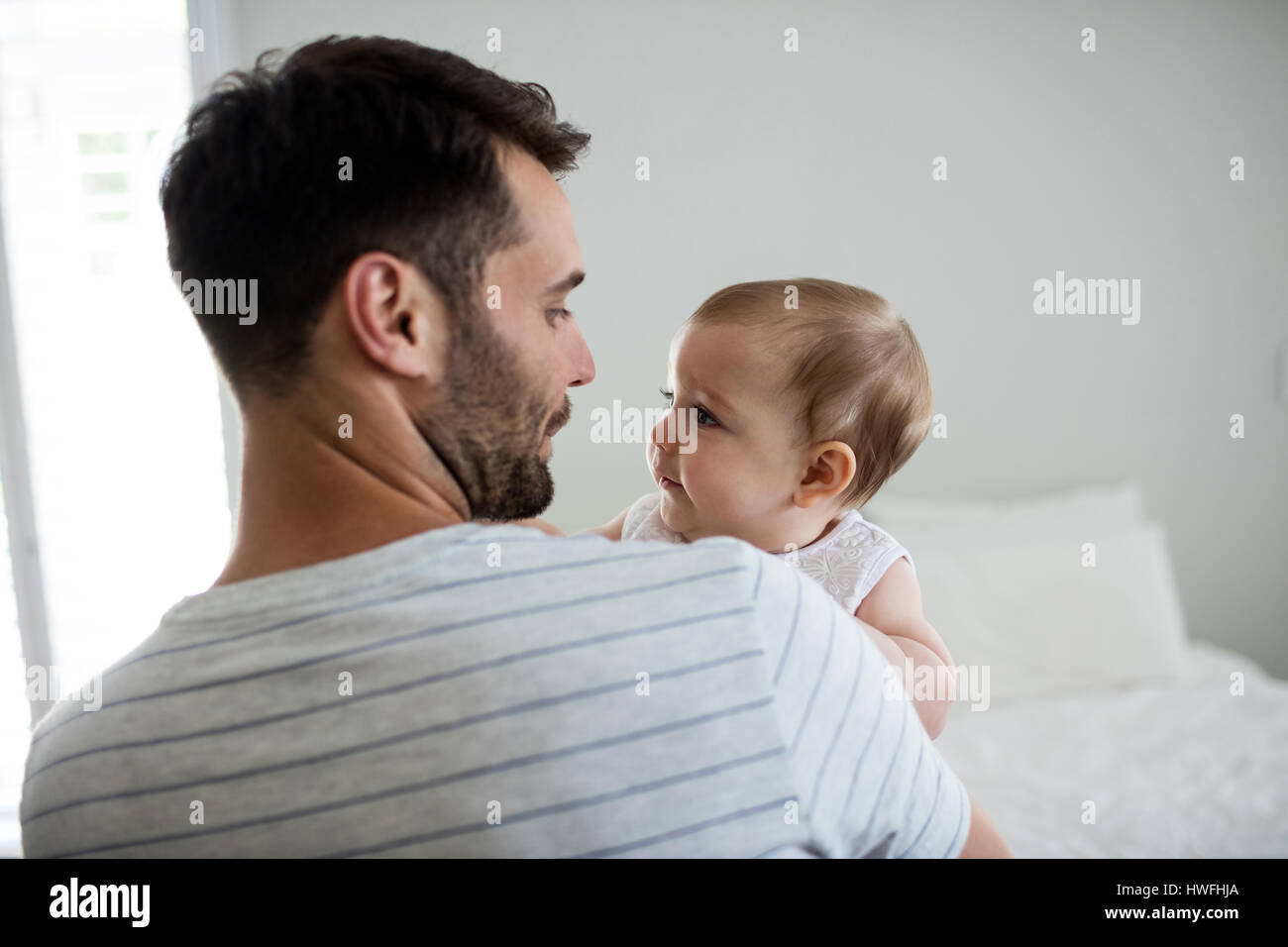 Father holding his baby girl at home Stock Photo - Alamy