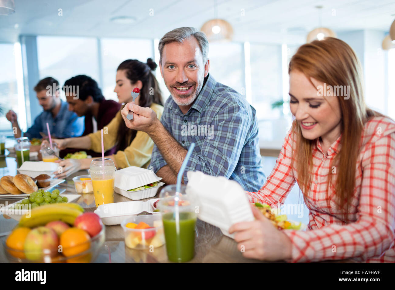 Creative business team having meal at office Stock Photo - Alamy