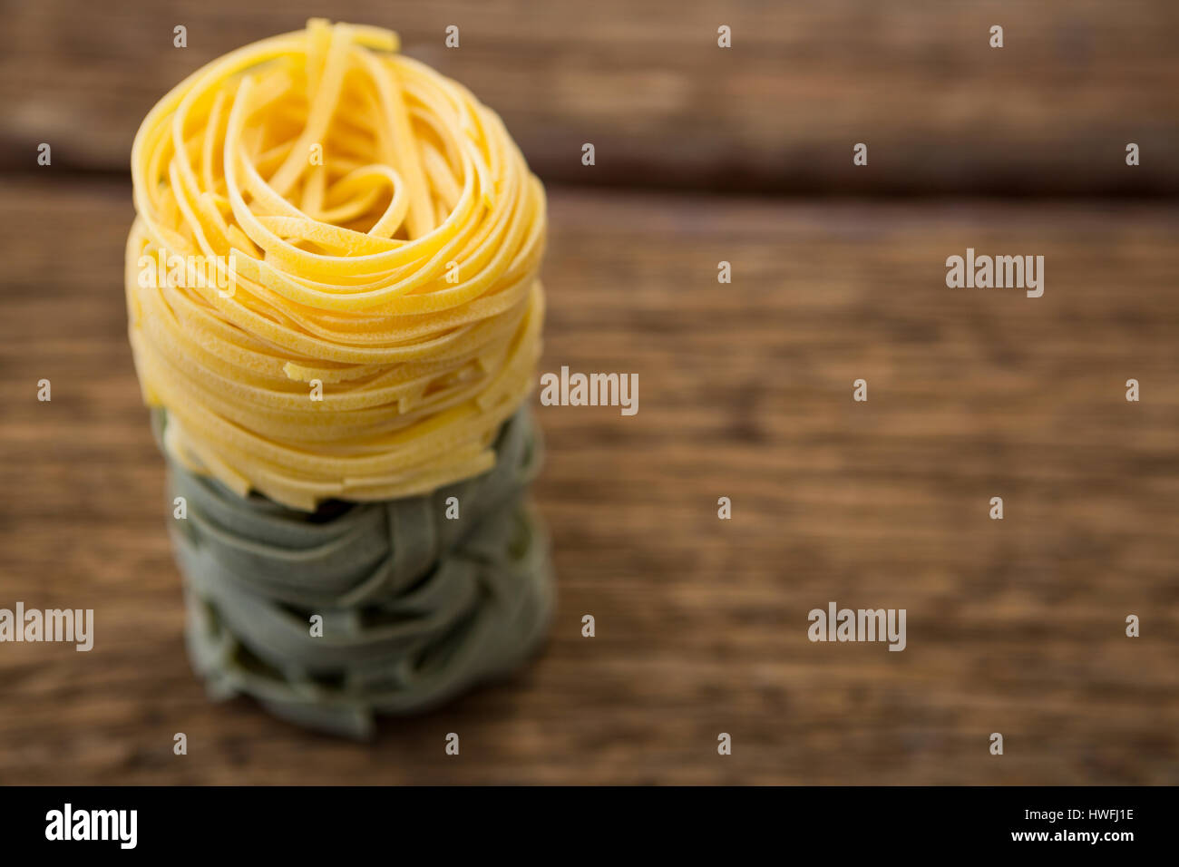 Stack of tagliatelle pasta on wooden surface Stock Photo - Alamy