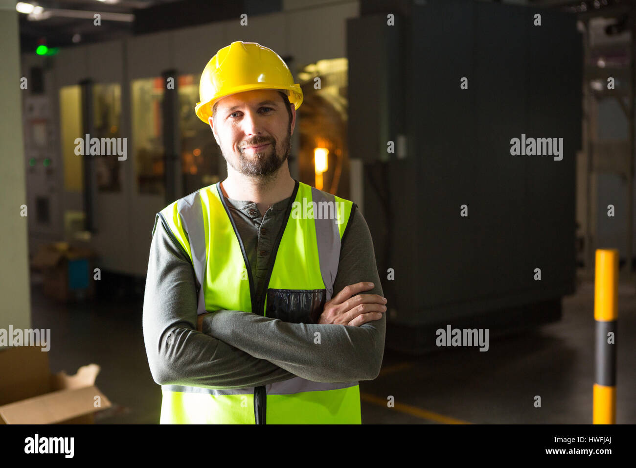 Portrait of young male worker standing in factory Stock Photo - Alamy
