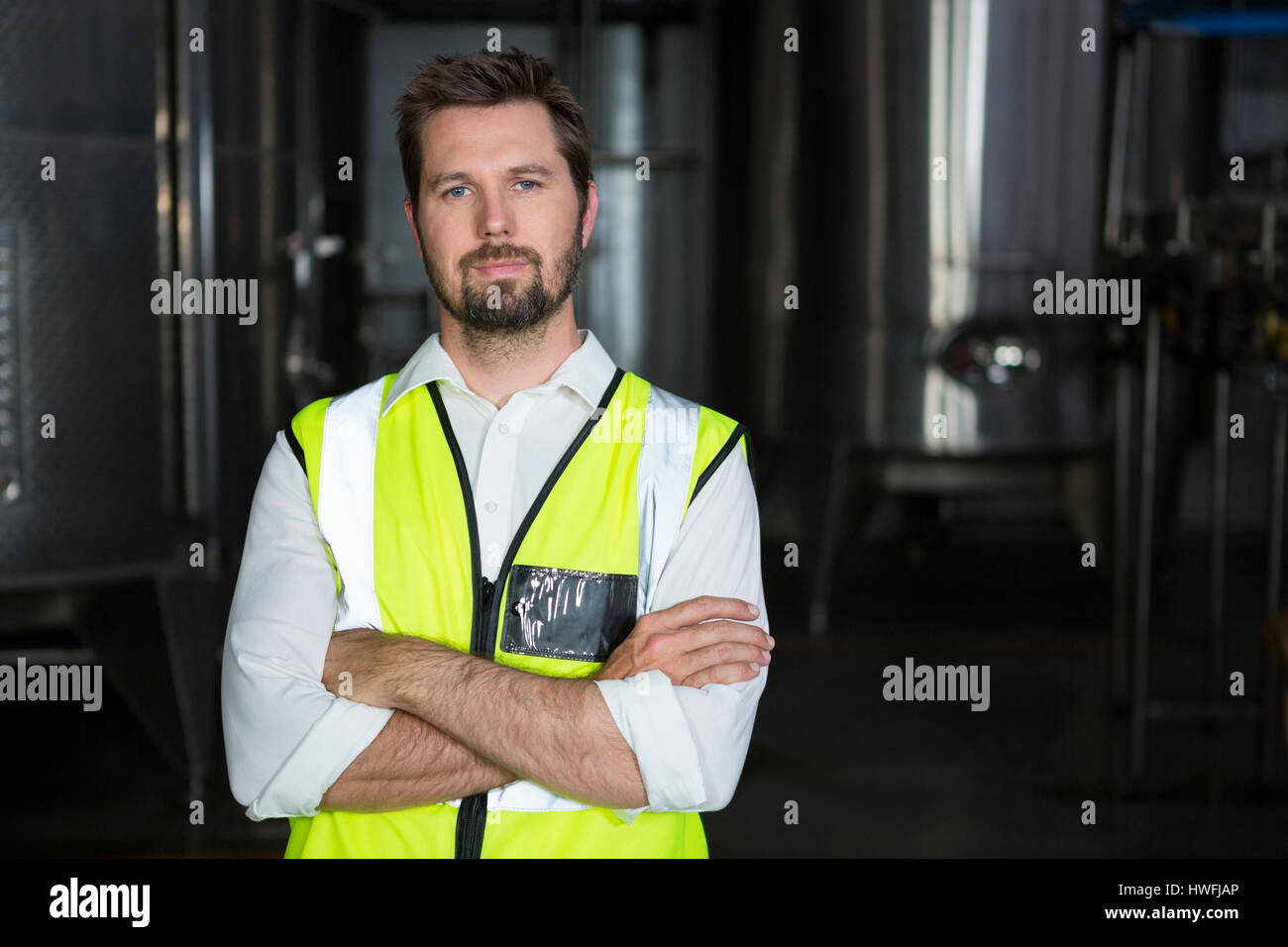 Portrait of male worker with arms crossed standing in factory Stock ...