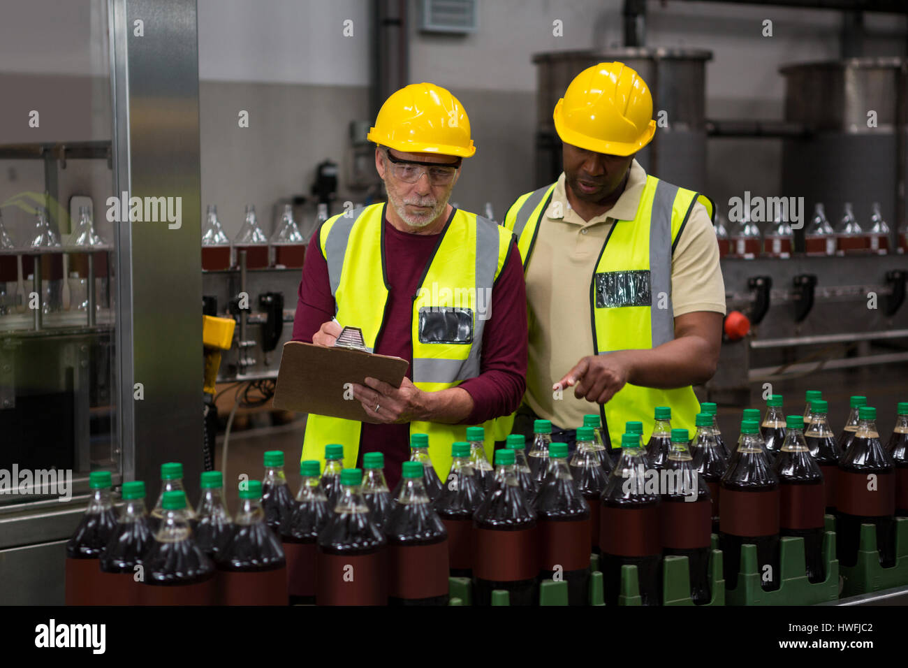 Male workers discussing in juice factory Stock Photo - Alamy