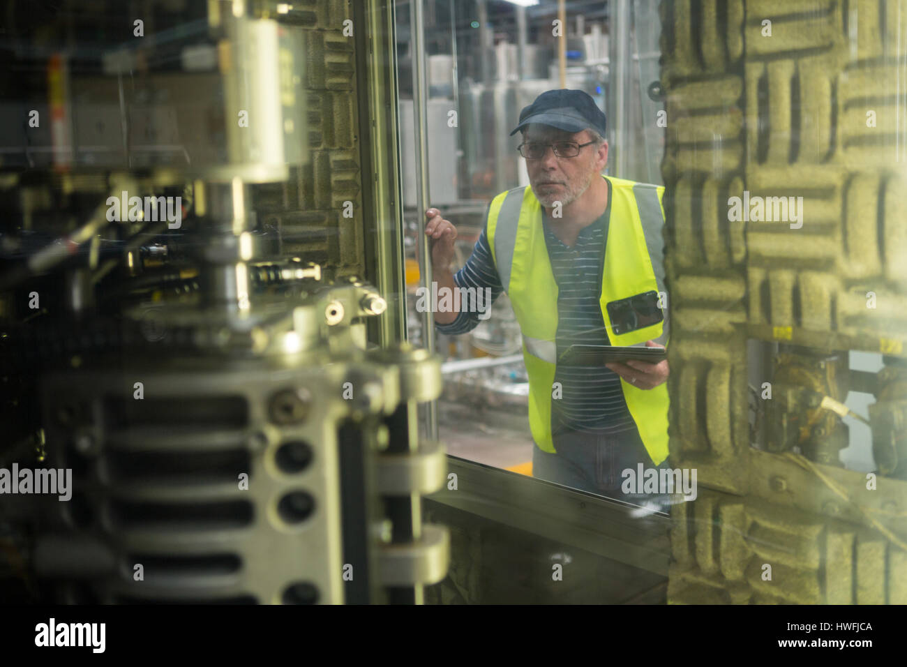 Employee watching machinery at juice factory Stock Photo - Alamy