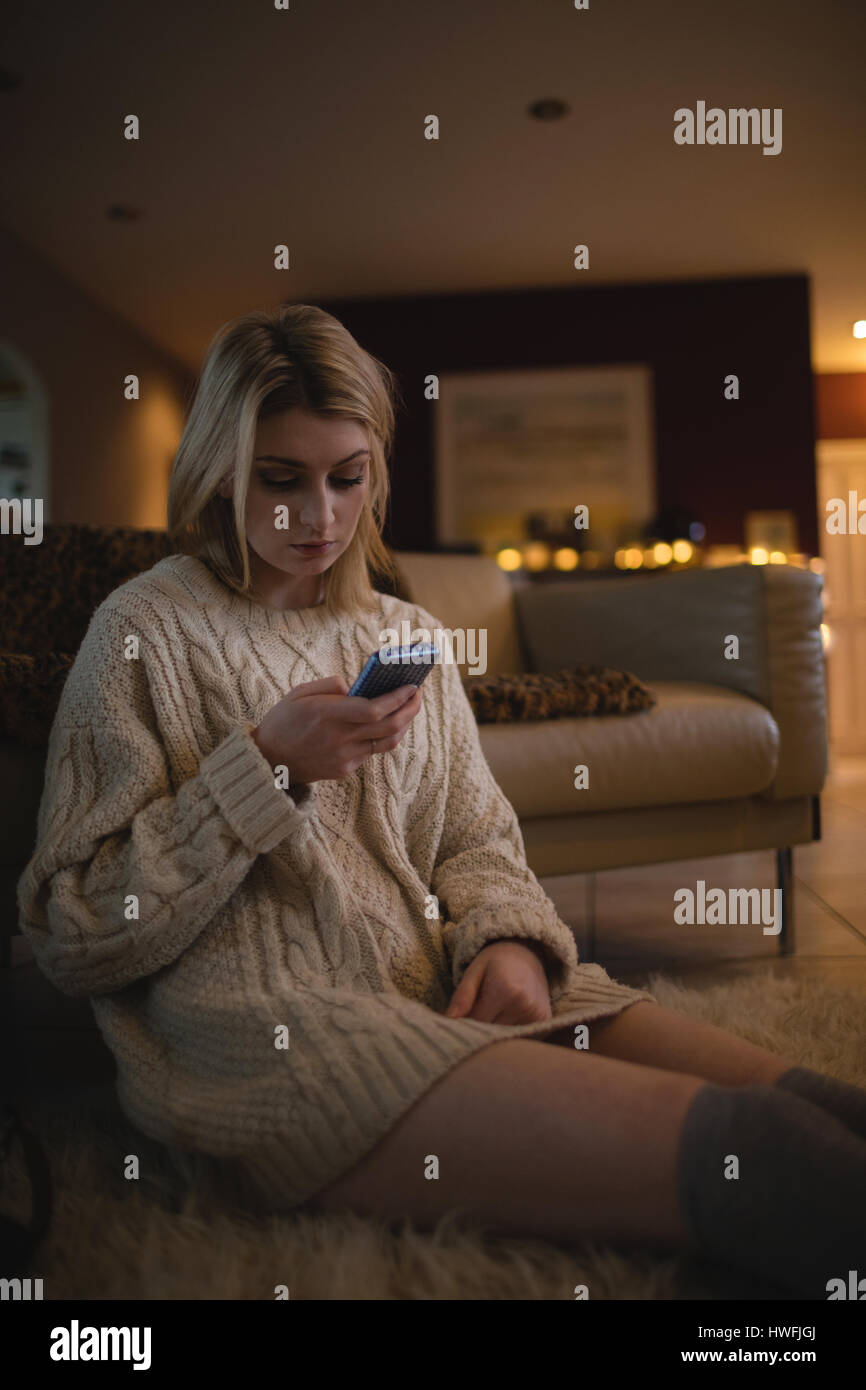 Woman using mobile phone while sitting at home Stock Photo - Alamy