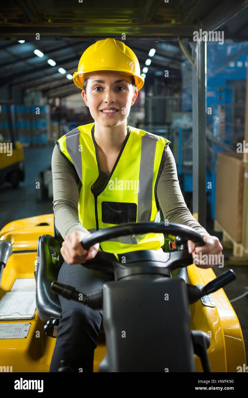 Portrait of beautiful female worker driving forklift in warehouse Stock ...