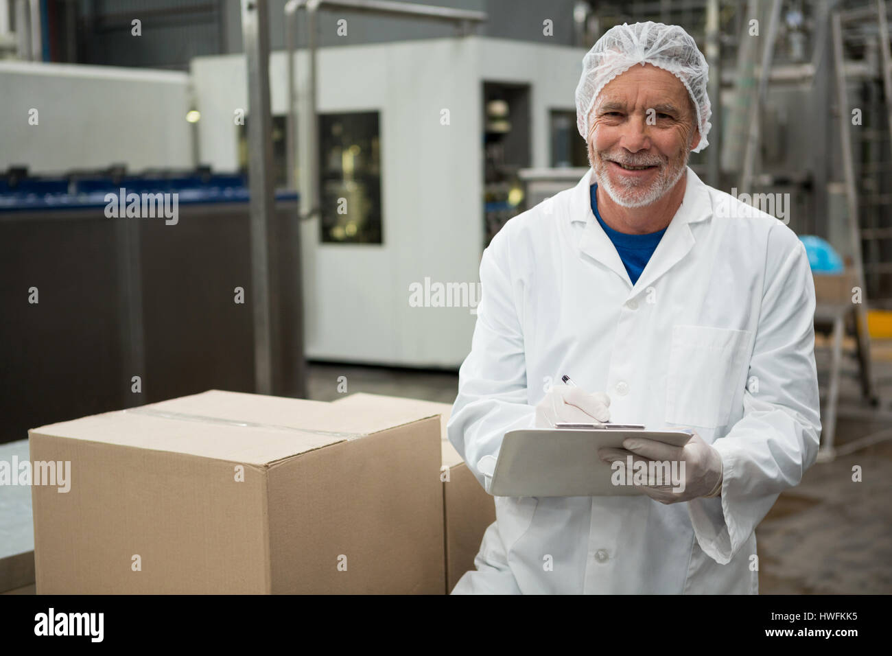 Portrait of male worker writing on notepad in cold drink factory Stock ...