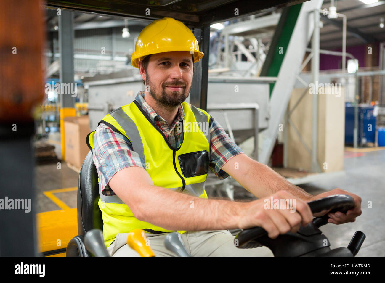Portrait of young male worker driving forklift in warehouse Stock Photo ...