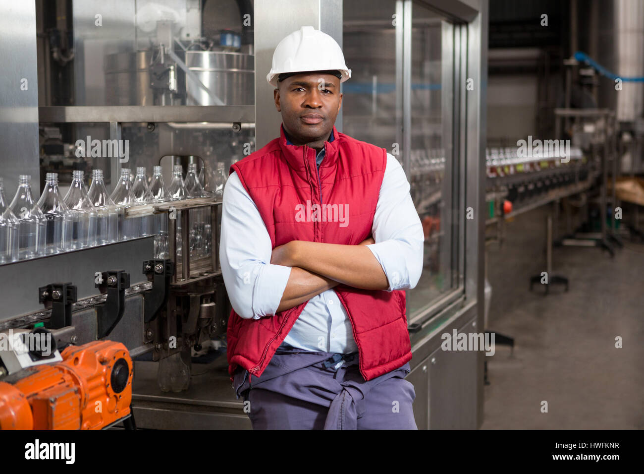 Portrait of confident male employee standing by production line in ...