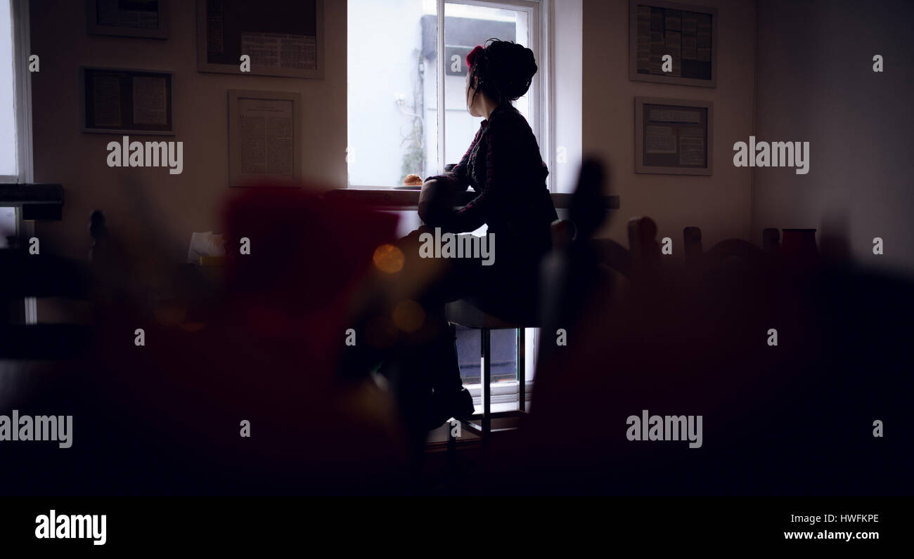 Rear view of woman looking through window in cafÃƒÂ© Stock Photo - Alamy