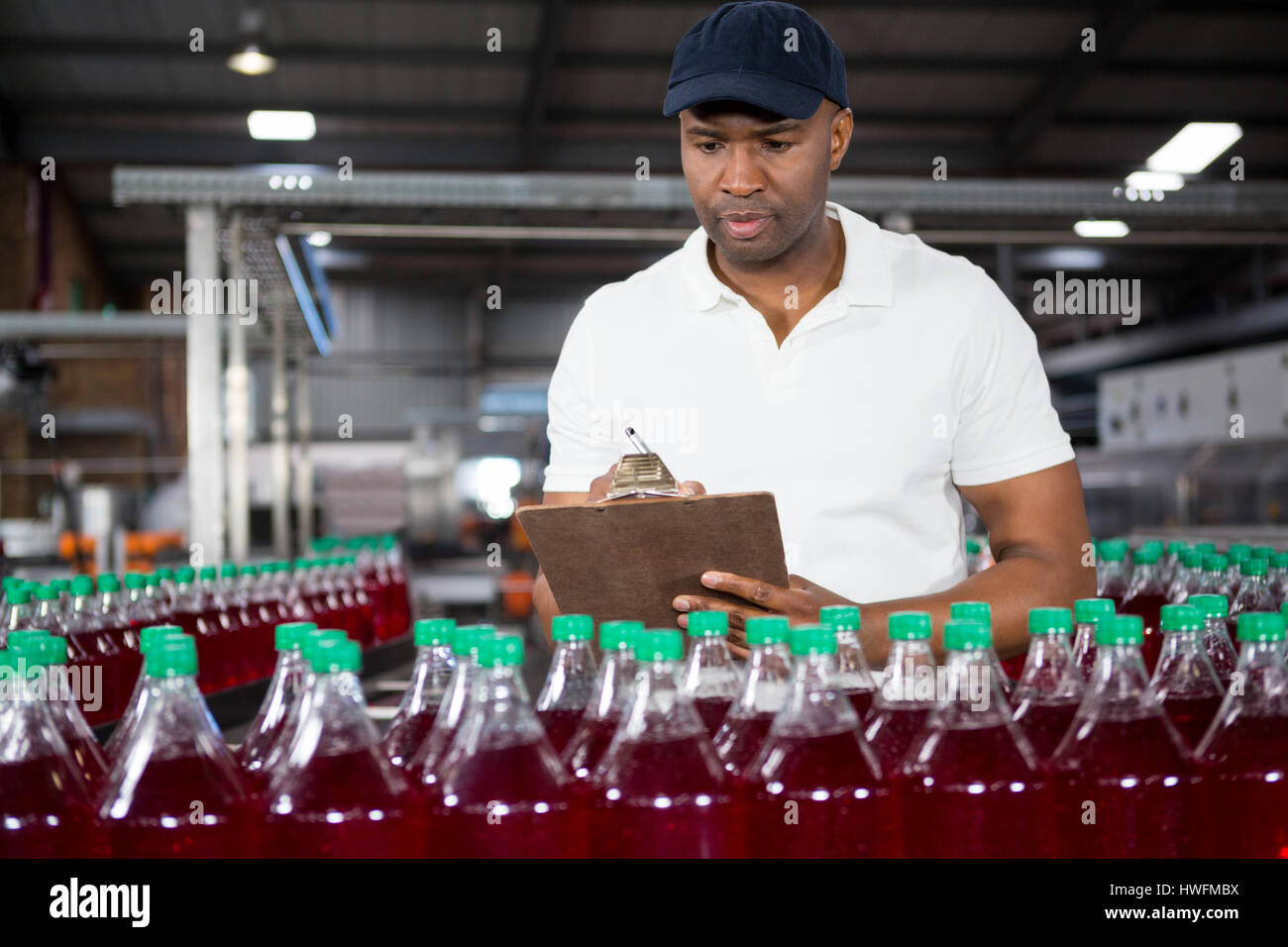 Confident male worker writing on clipboard in factory Stock Photo - Alamy