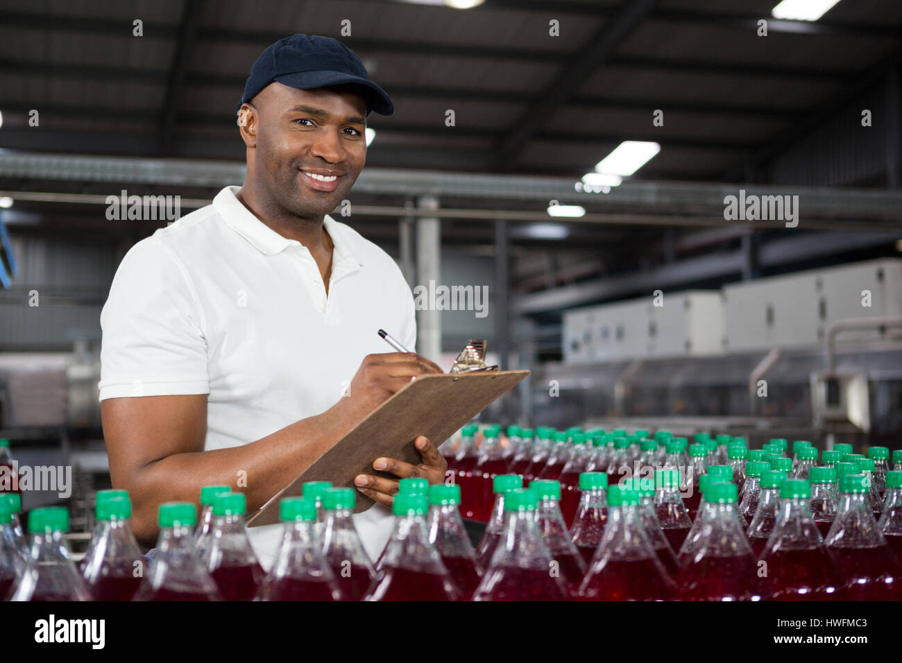 Portrait of young male worker noting in juice factory Stock Photo - Alamy