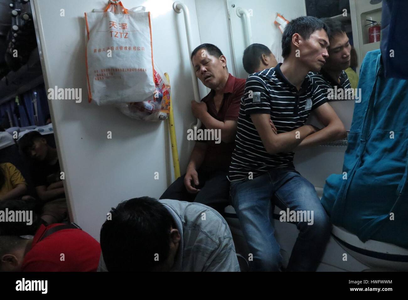 Xian, China. 20th Mar, 2017. Passengers sleep on the corridor of a ...
