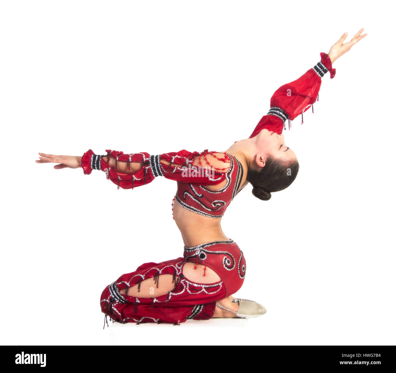 A young woman in stage costume shows gymnastics. Studio shooting stage ...
