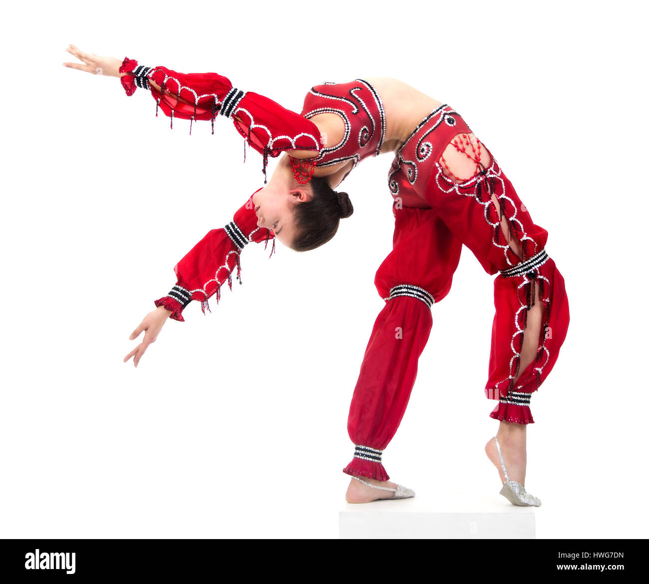 A young woman in stage costume shows gymnastics. Studio shooting stage ...