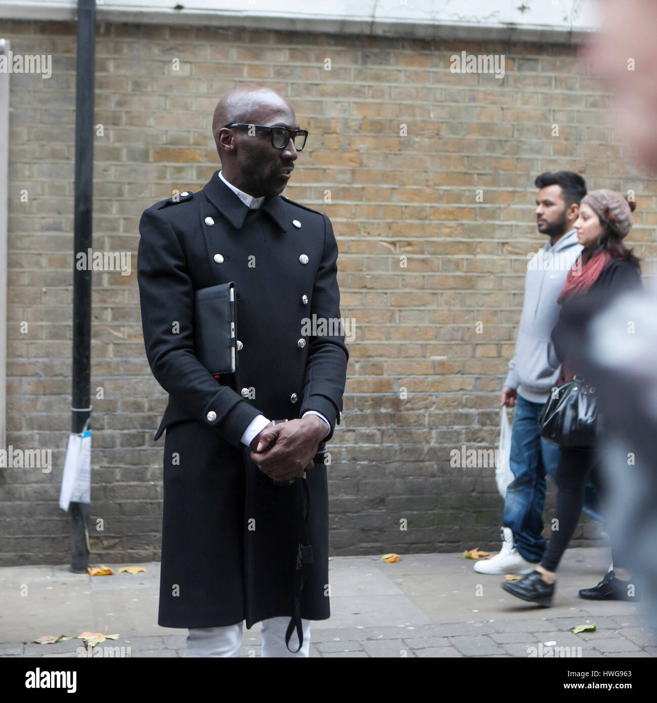 LONDON, ENGLAND - JULY 12, 2016 A fashionable black man stands opposite ...