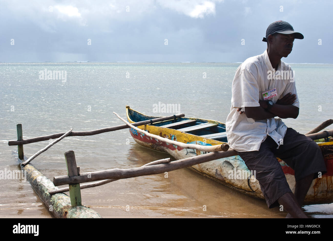 Beach attendant waiting for clients to take a boat ride on the lagoon ...