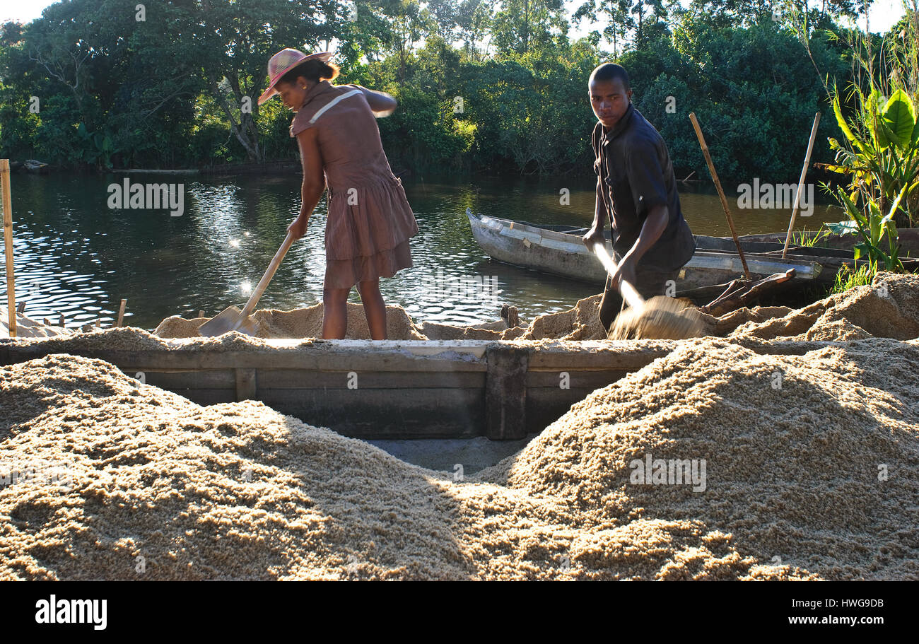 Man and woman loading sand in a pick up truck ( Madagascar). The sand ...