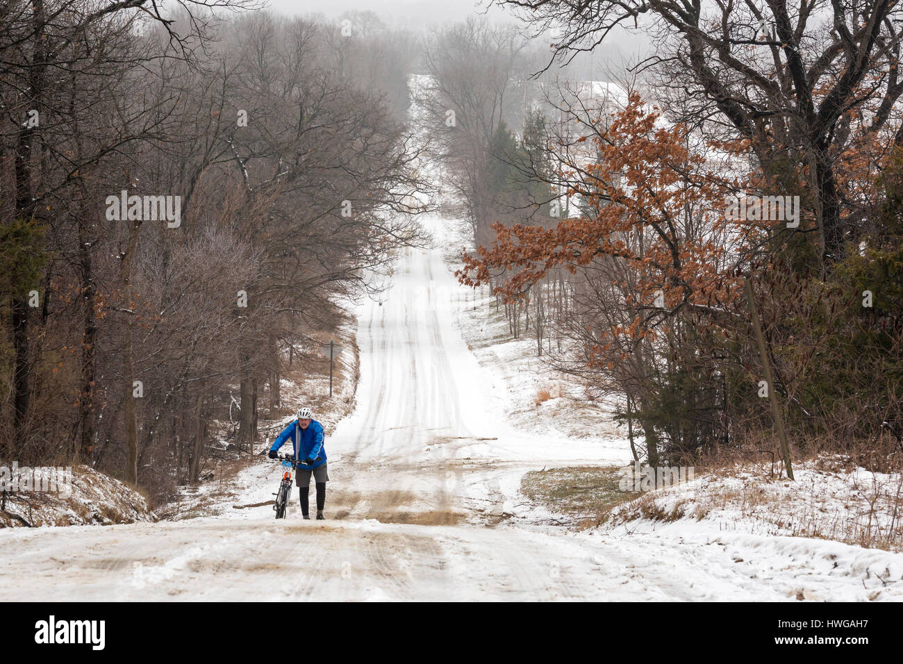 Grass Lake, Michigan - Tim Hoeffner pushes his bike up one of the ...
