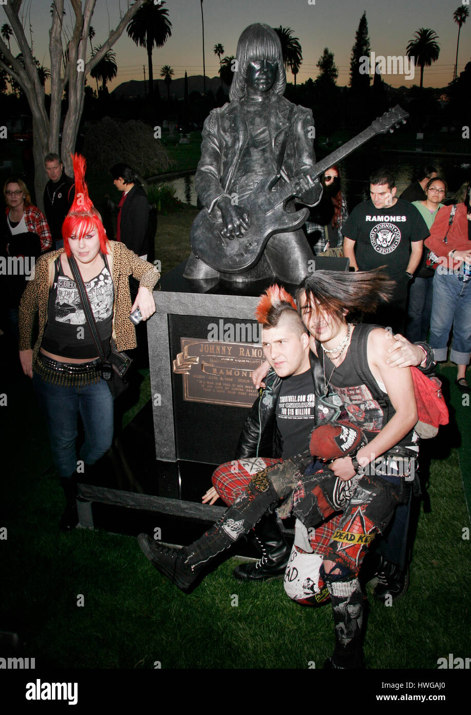 Fans gather around the statue of punk guitarist Johnny Ramone at the ...