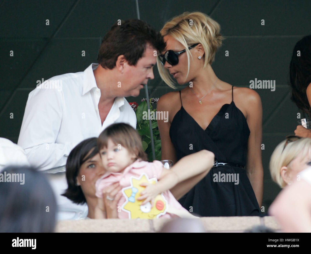 Victoria Beckham talks with Simon Fuller in a luxury suite during a Los ...