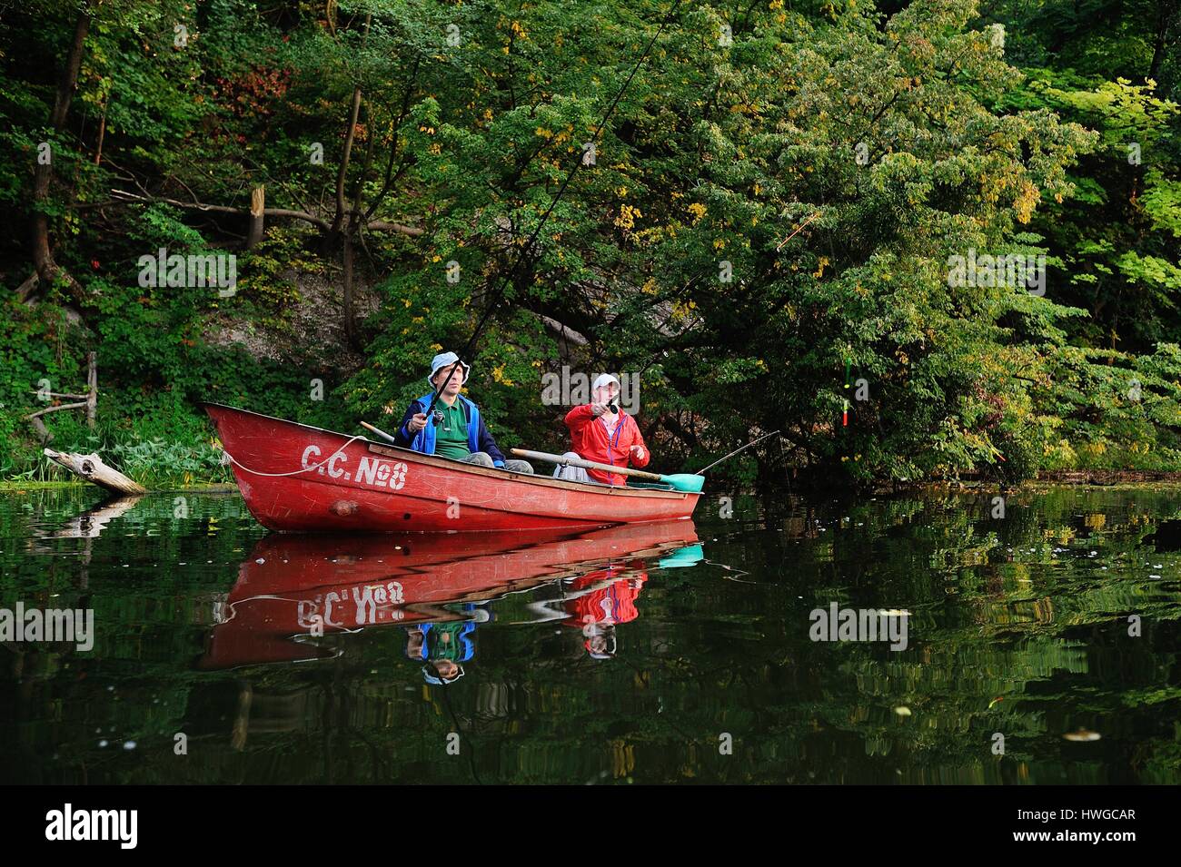 Two fishermen in a boat with fishing rods catching fish Stock Photo - Alamy