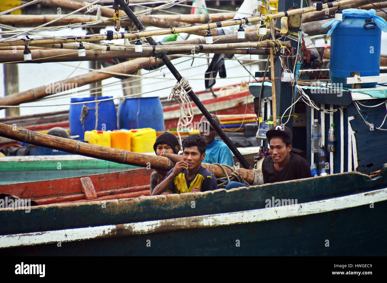 Fishermen sit in a fishing boat on the beach in the village of Makyone ...