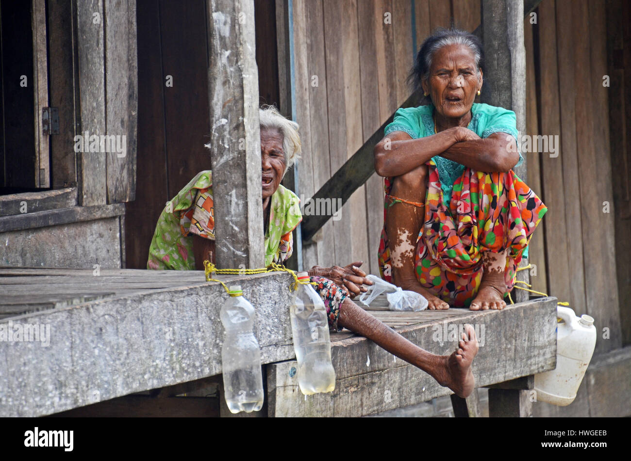 Two elderly Moken women sit outside a house in the village of Makyone ...