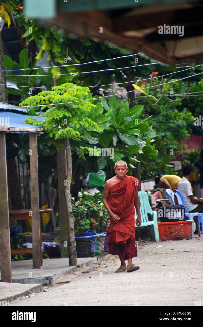 A monk wals through the village of Makyone Galet, Lampi National Marine ...