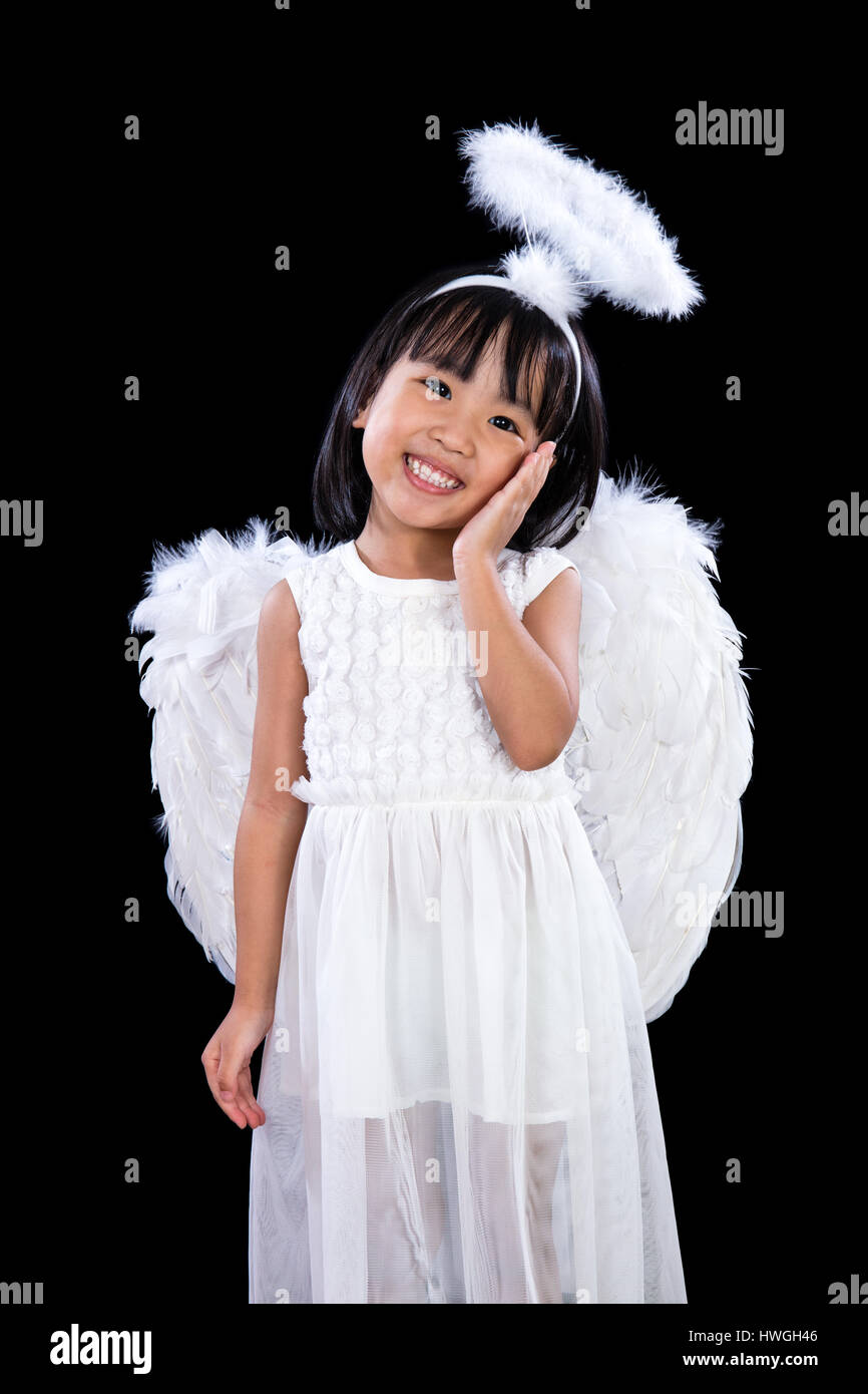 Smiling Asian Chinese Little Angel in dark black isolated studio ...