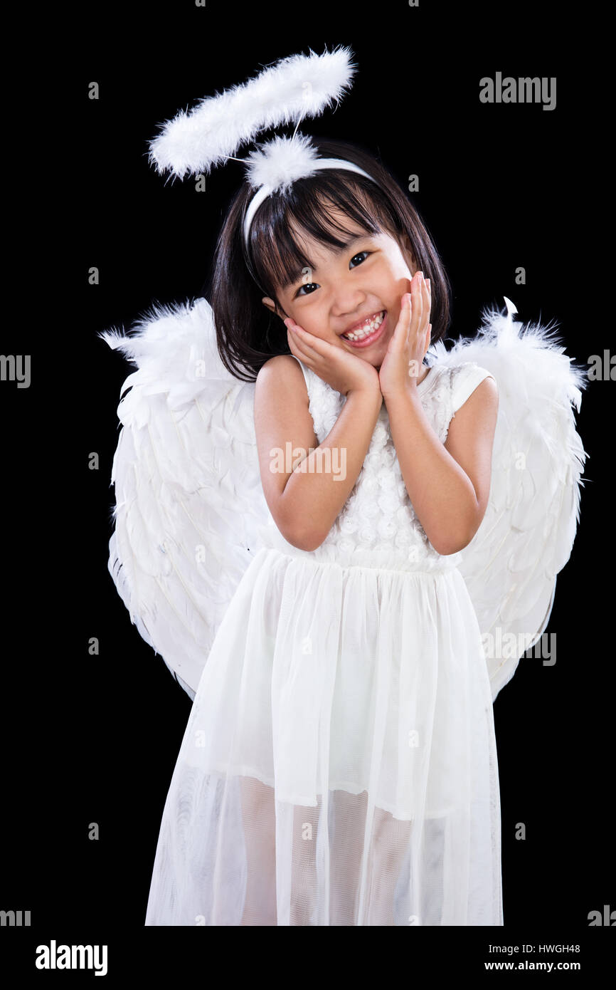 Smiling Asian Chinese Little Angel in dark black isolated studio ...