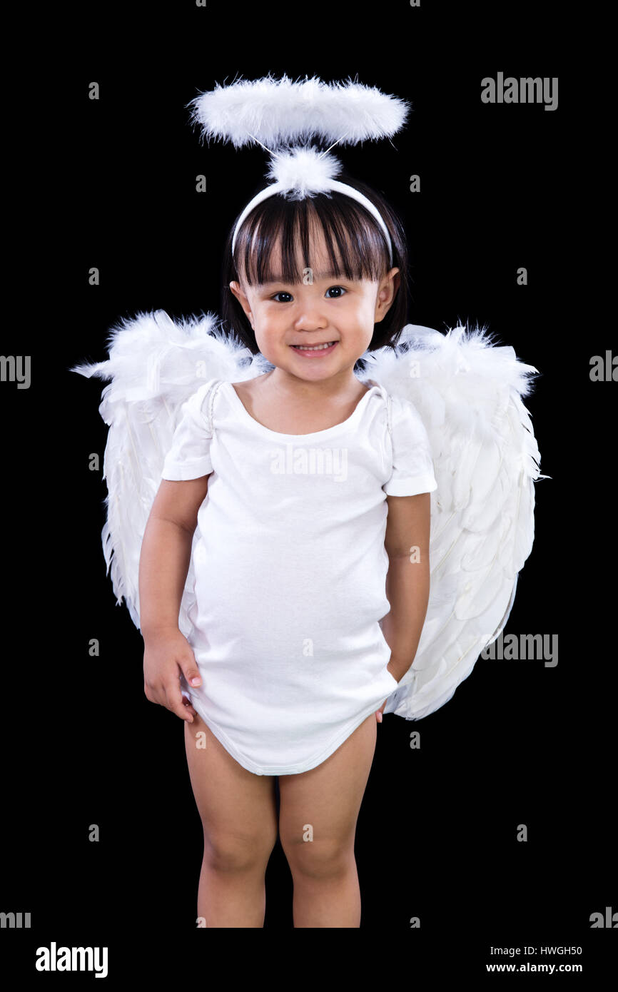 Smiling Asian Chinese Little Angel in dark black isolated studio ...