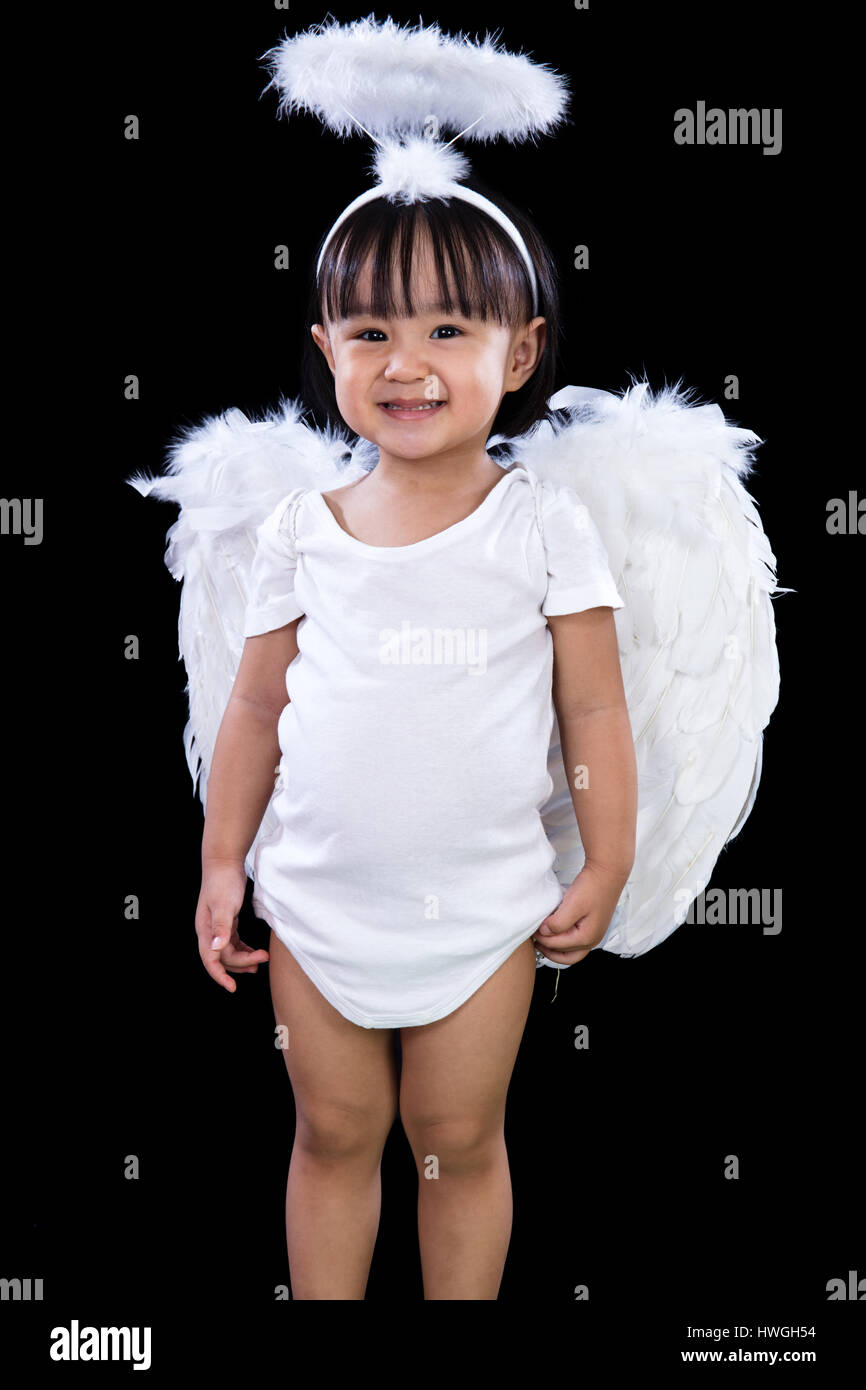 Smiling Asian Chinese Little Angel in dark black isolated studio ...