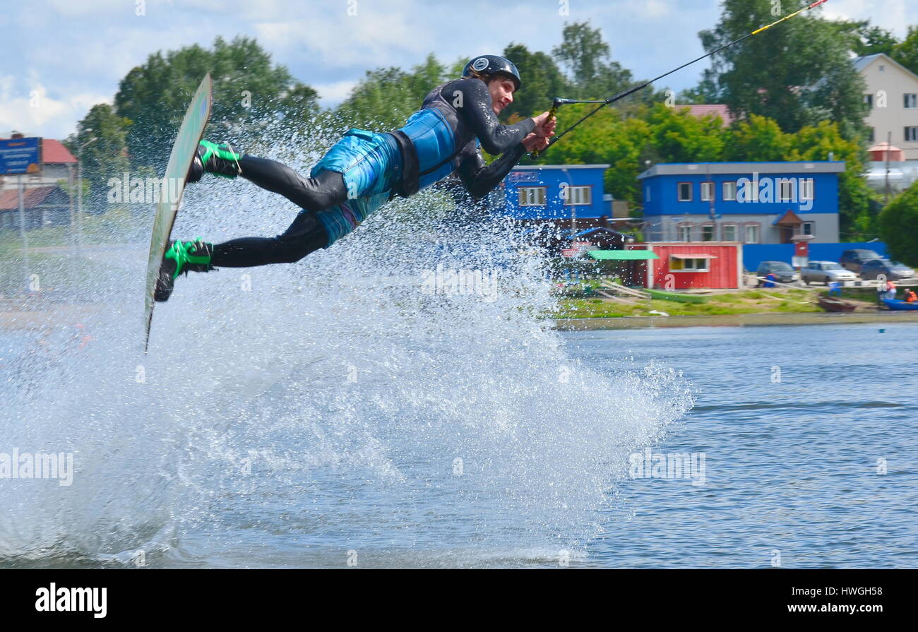 Water snowboard. The athlete with snowboard hold on to the rope and the ...