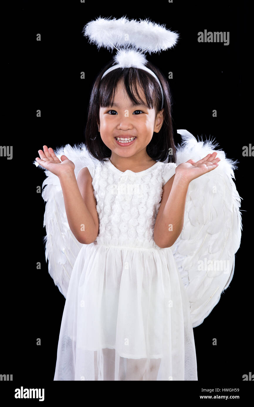 Smiling Asian Chinese Little Angel in dark black isolated studio ...