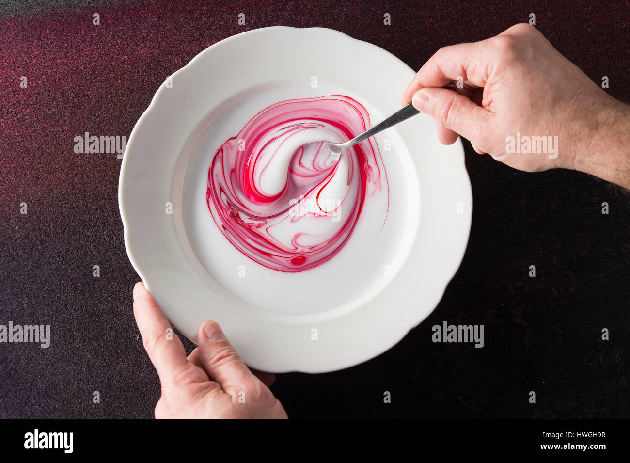 Block printing, hand mixing red pigment color and white binder with ...