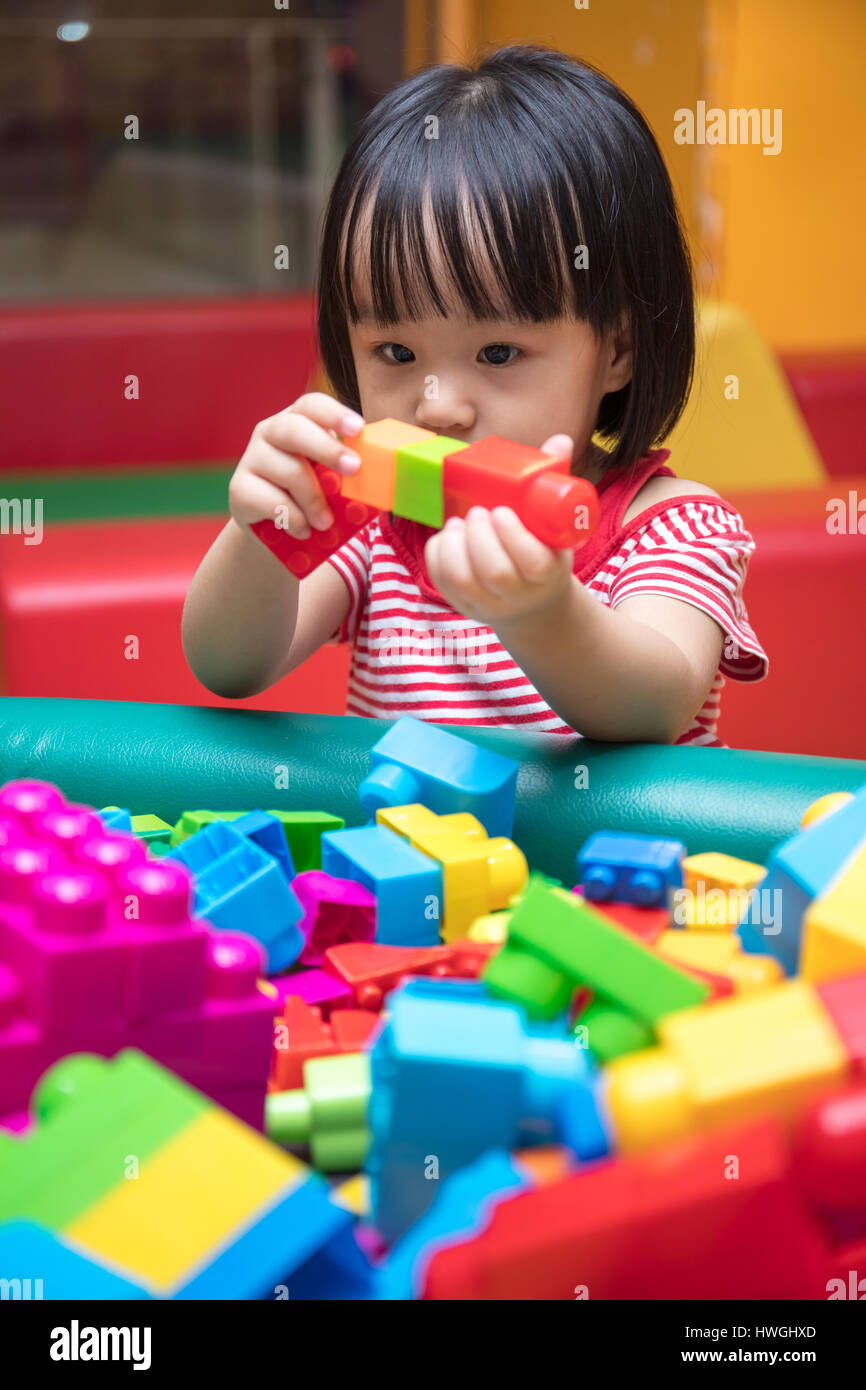 Asian Chinese little girl building blocks at indoor playground alone ...