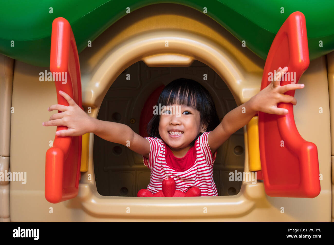 Asian Chinese little girl playing in toy house at indoor playground ...