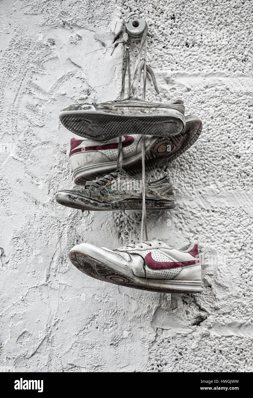 Old Nike trainers hanging from exterior wall Stock Photo - Alamy