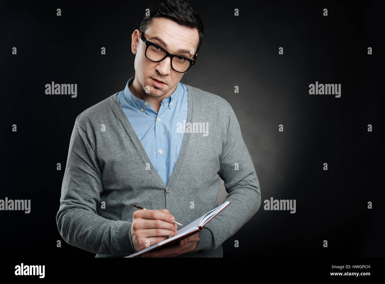 Serious brunette male person making some notes Stock Photo - Alamy