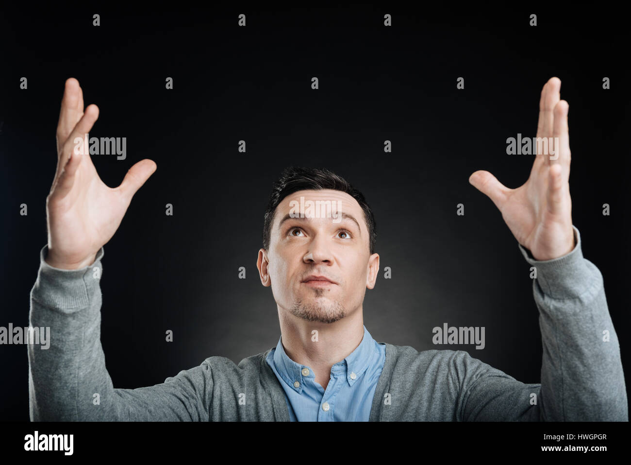 Concentrated brunette rising his hands Stock Photo - Alamy