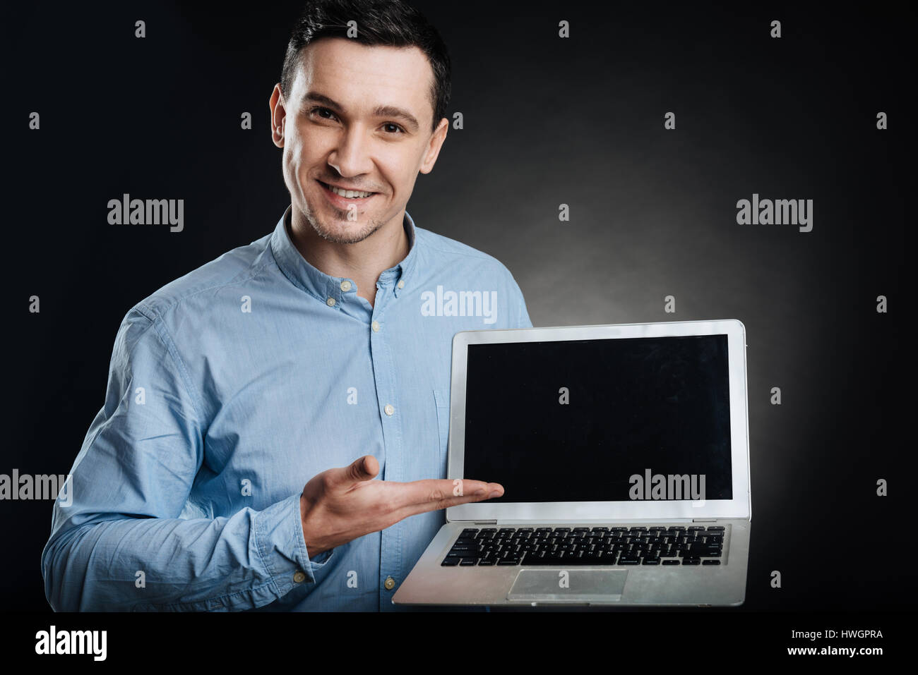 Attractive male presenting his laptop Stock Photo - Alamy