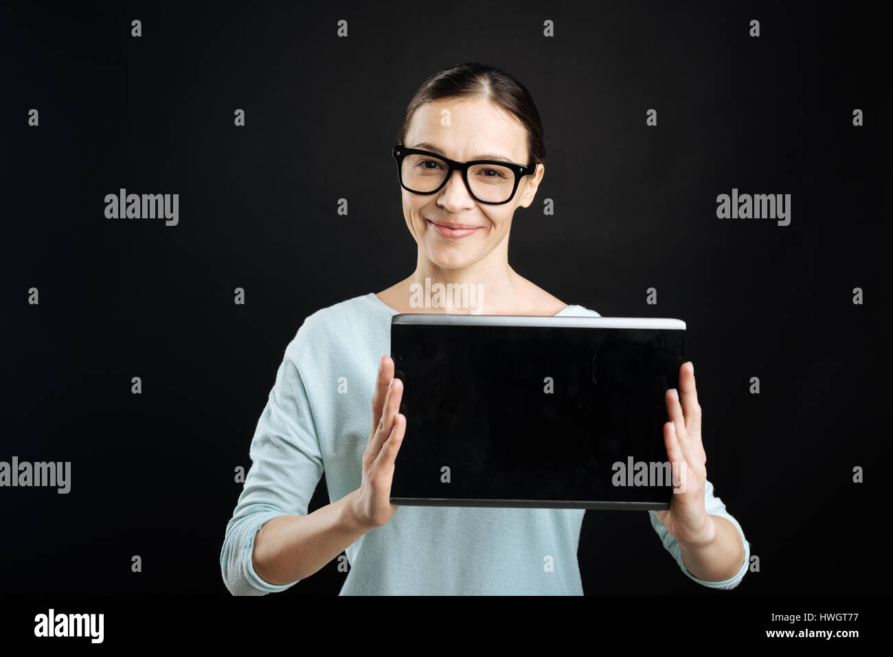 Friendly girl holding tablet before herself Stock Photo - Alamy