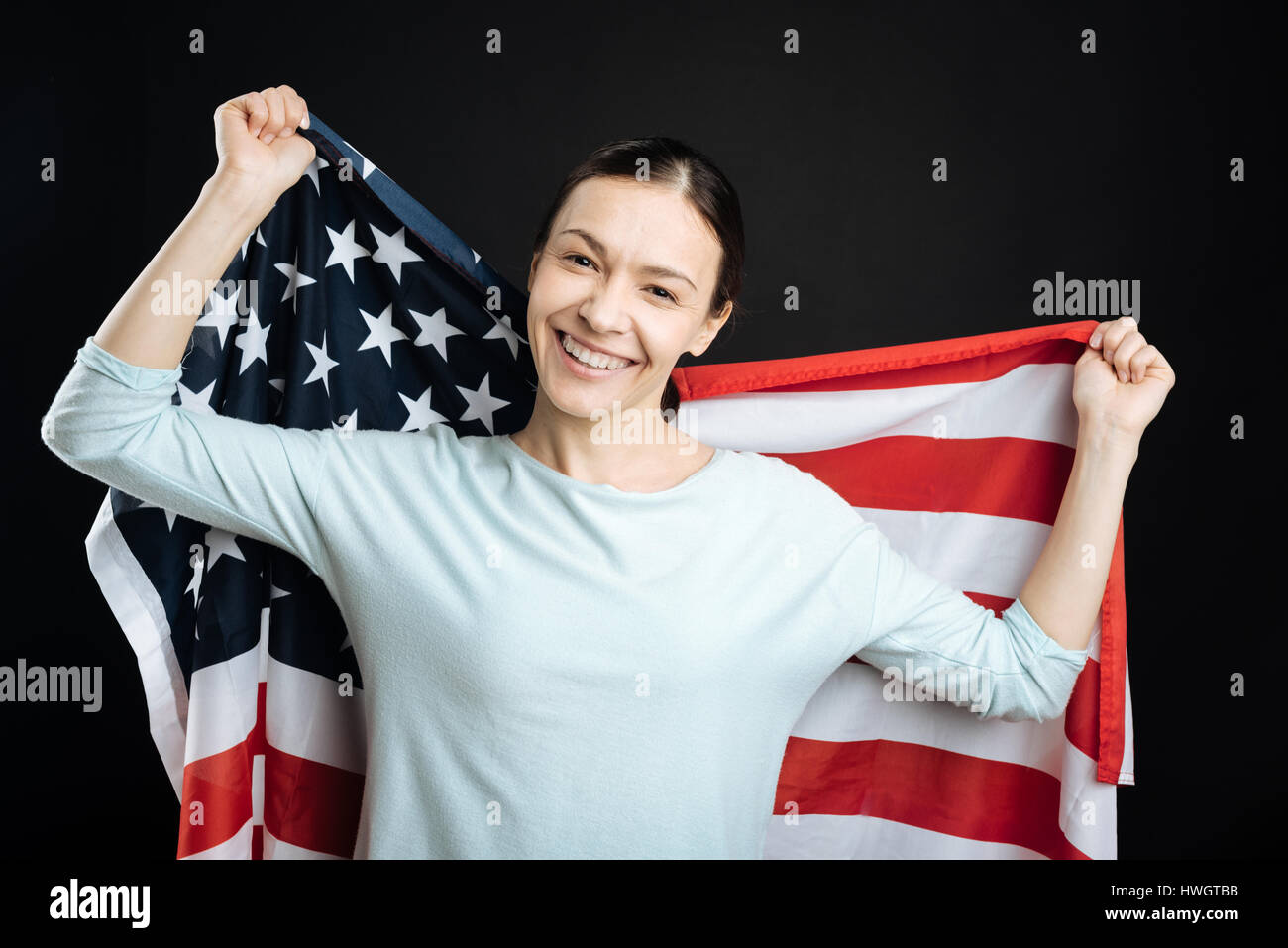 Positive female holding big flag on the background Stock Photo - Alamy