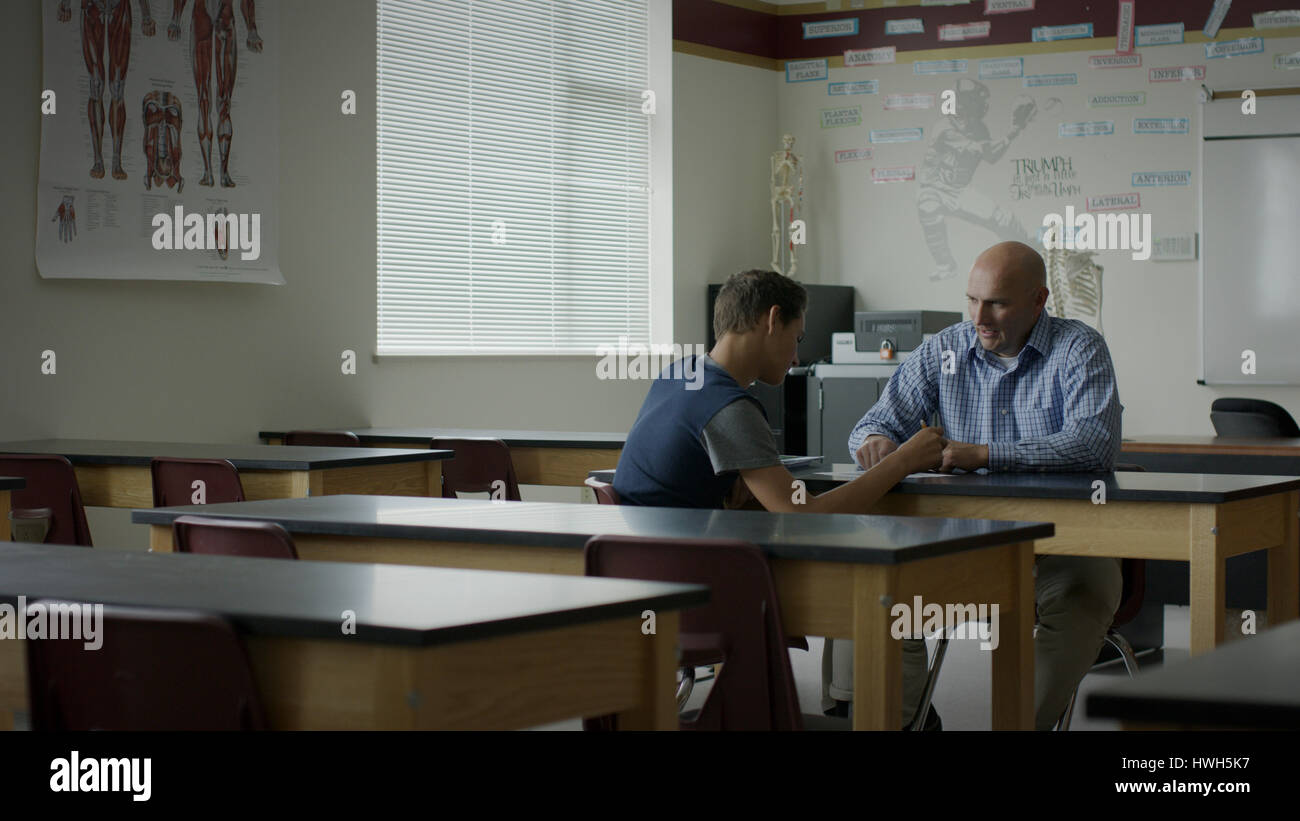 Teacher instructing and tutoring student in classroom Stock Photo - Alamy