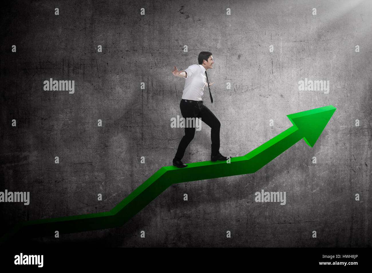Asian business man balancing increasing arrow chart Stock Photo - Alamy